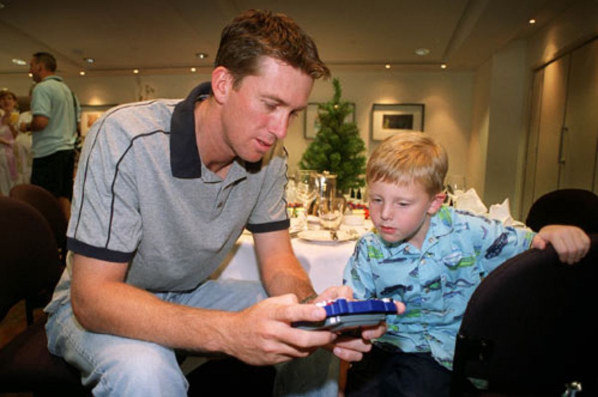 Glenn McGrath plays a videogame with a boy | ESPNcricinfo.com