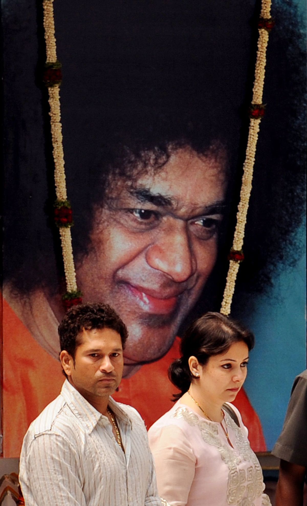 Sachin Tendulkar and wife Anjali stand in front of a portrait of ...