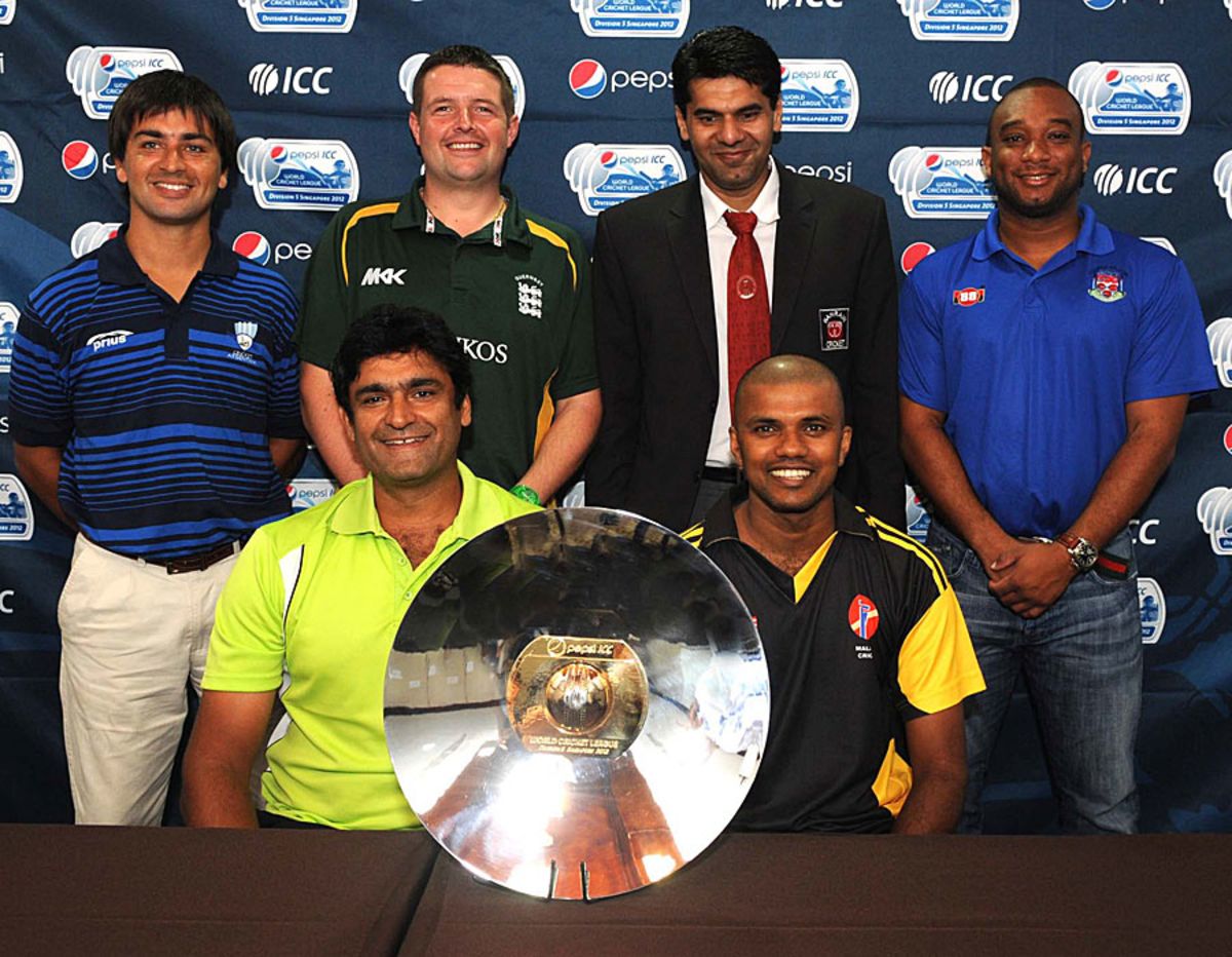 Captains pose with the ICC World Cricket League Division 5 trophy ...