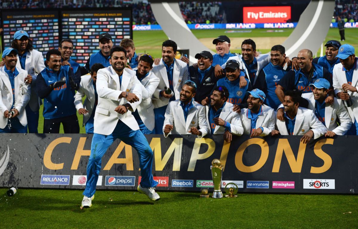 The victorious Indian team pose behind the Champions Trophy banner ...
