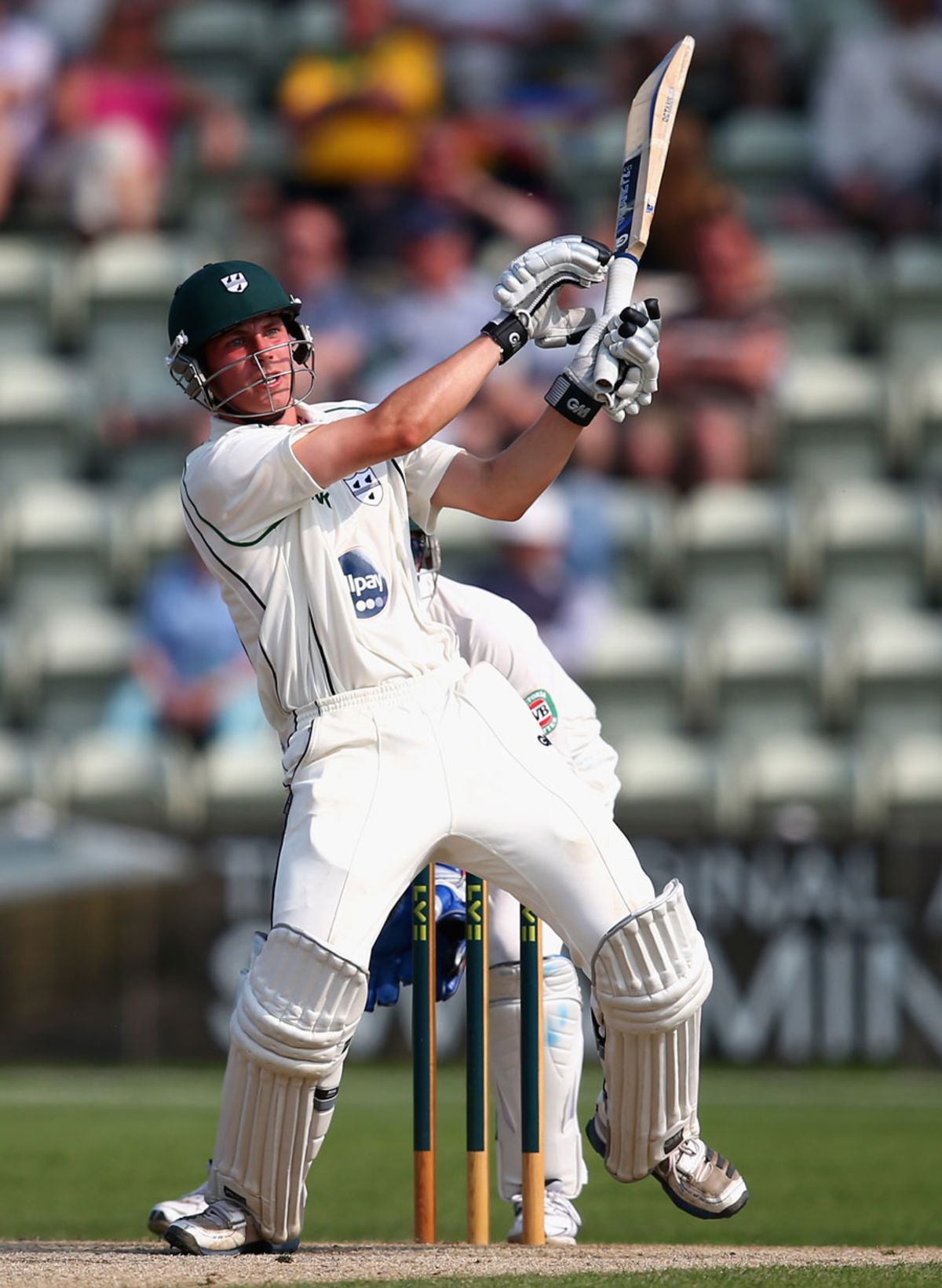 Tom Fell swings the ball away to the leg side with one hand ...