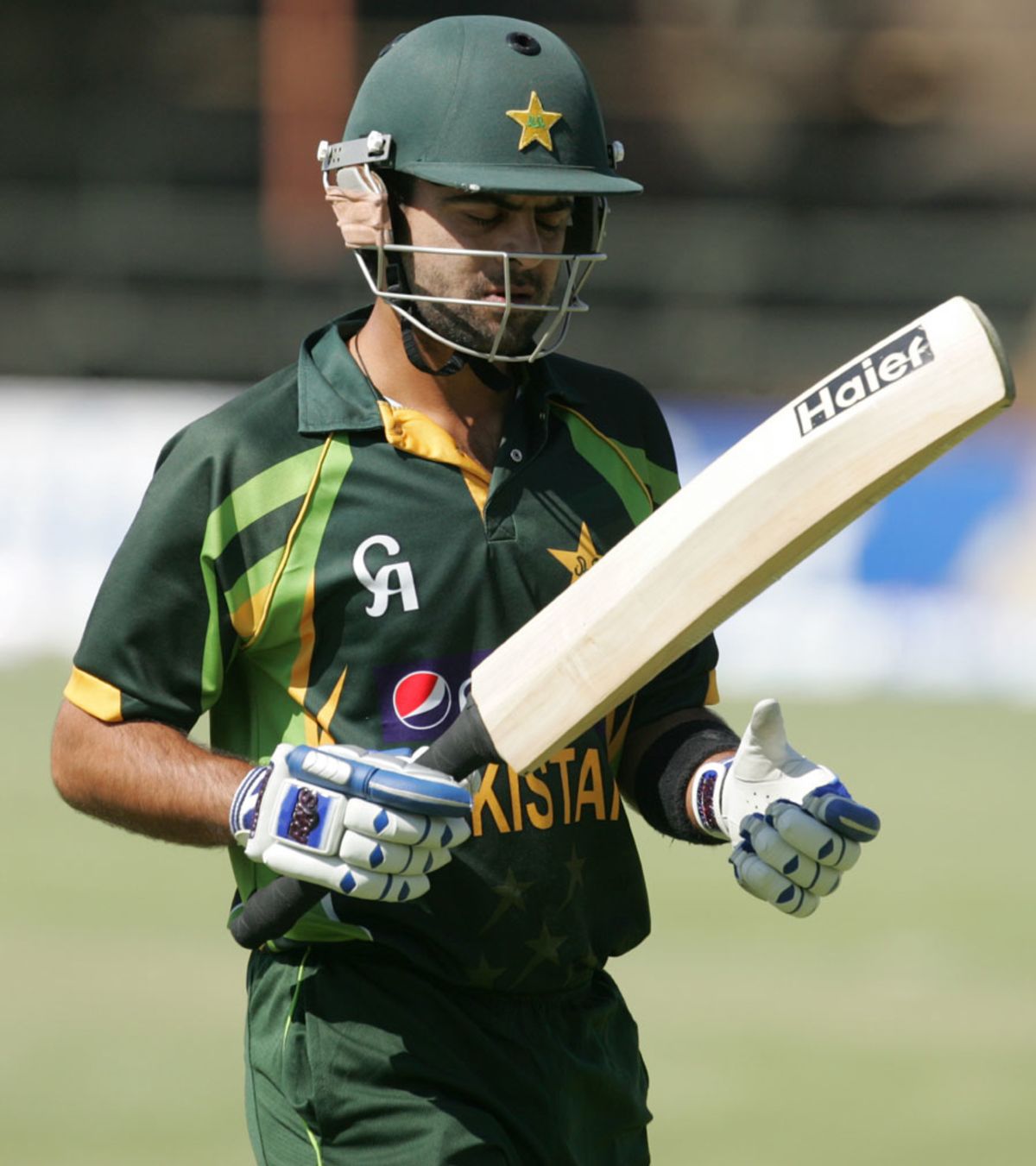 Ahmed Shehzad walks back after losing his wicket to Brian Vitori ...