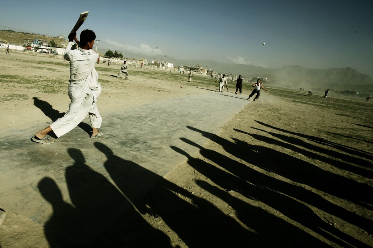 A youngster is watched while he bats in a local game in Afghanistan ...