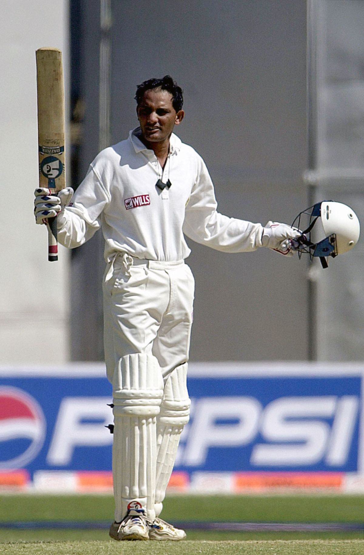 Azharuddin raises his bat after completing his century on his comeback ...