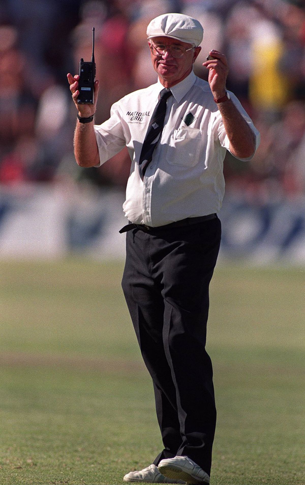Umpire Cyril Mitchley talks to the third umpire via walkie talkie ...
