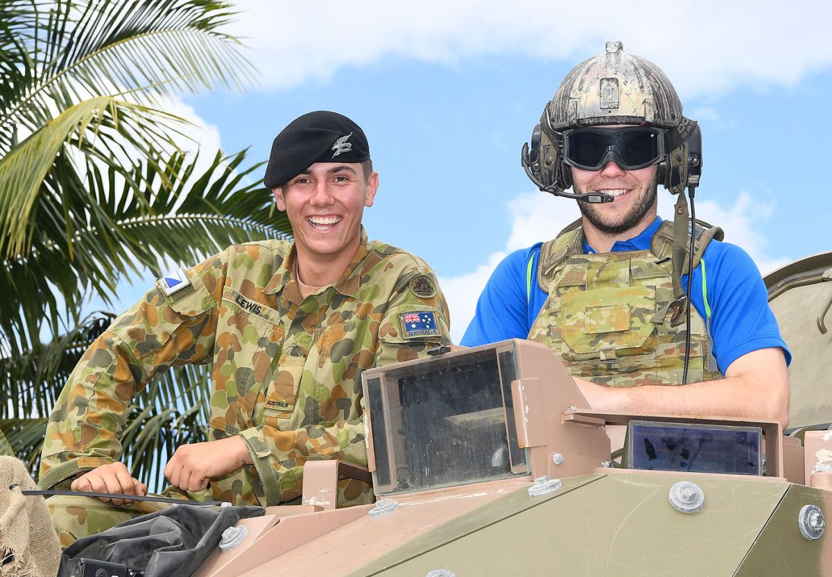 Caleb Jewell (right) poses on a tank next to a trooper | ESPNcricinfo.com