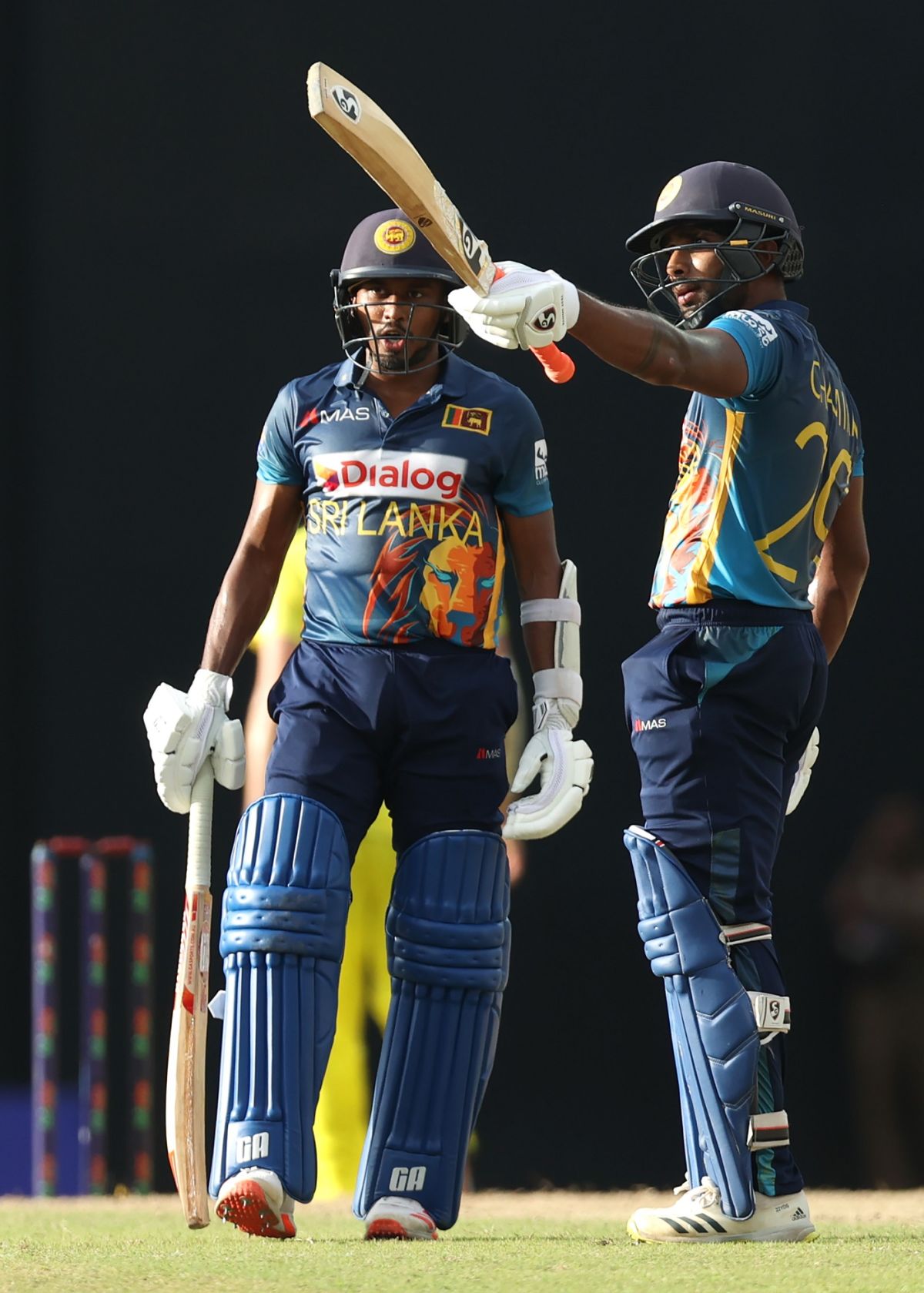 Chamika Karunaratne raises his bat after reaching a maiden ODI half-century as Pramod Madushan ...