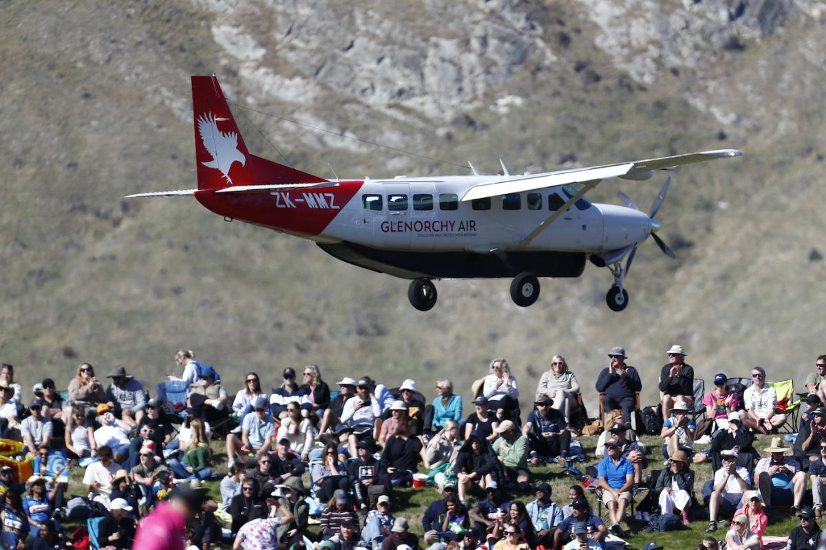 A plane flies over the crowd on the grass banks | ESPNcricinfo.com