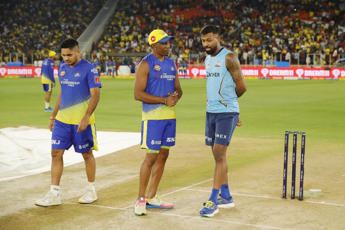 Tushar Deshpande checks out the pitch as Dwayne Bravo and Hardik Pandya have a chat ...