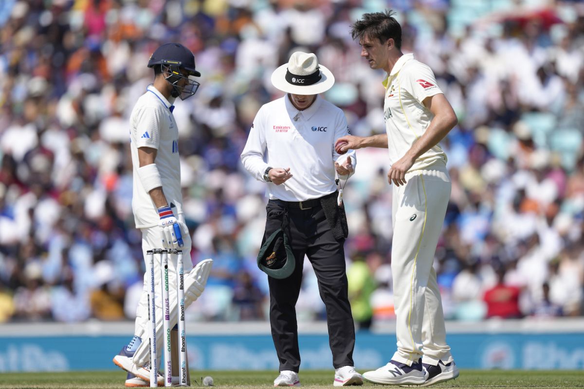 Shubman Gill looks as Pat Cummins collects the ball from Chris Gaffaney ...