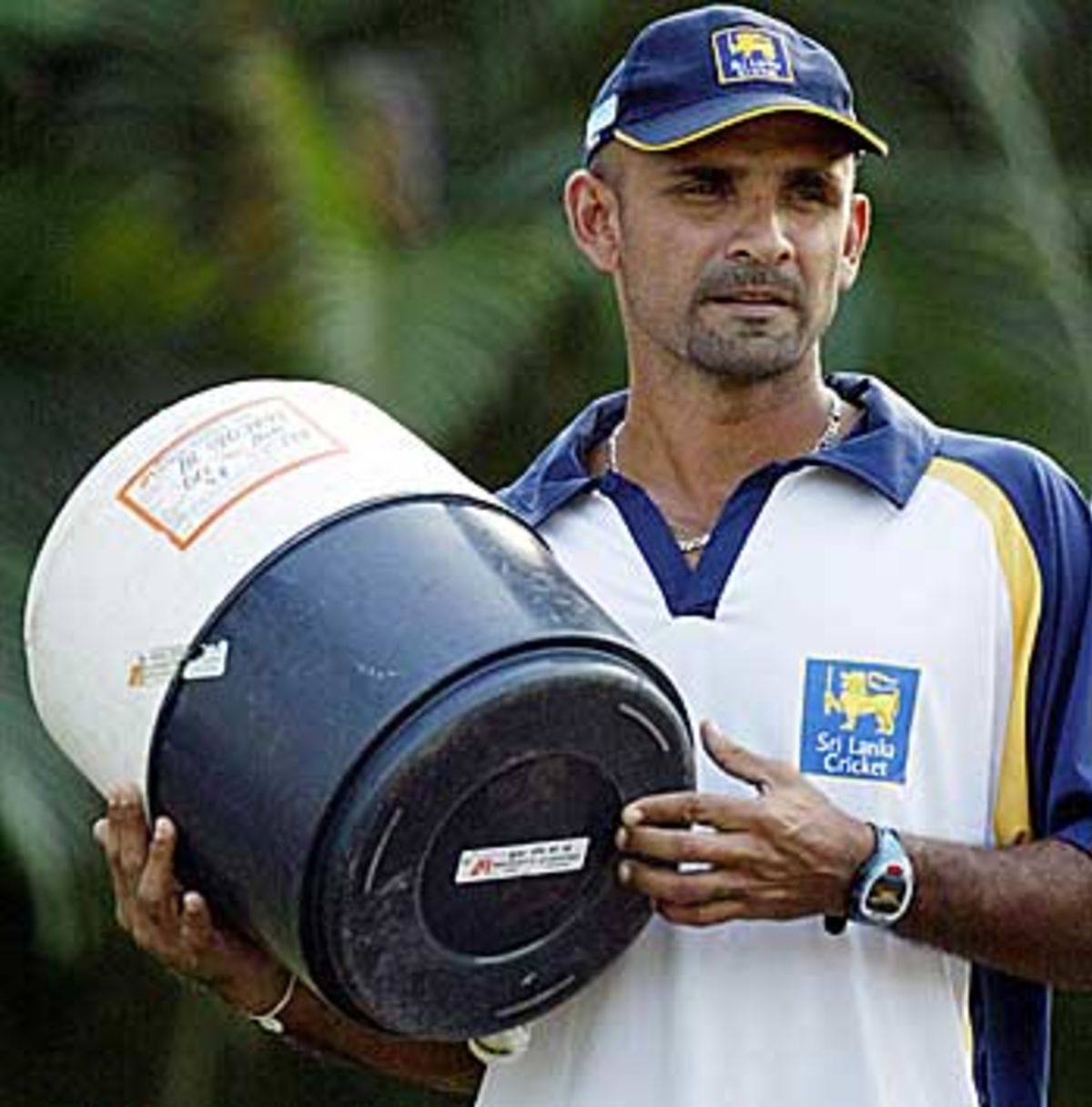 Marvan Atapattu carries a water container during a practice session ...