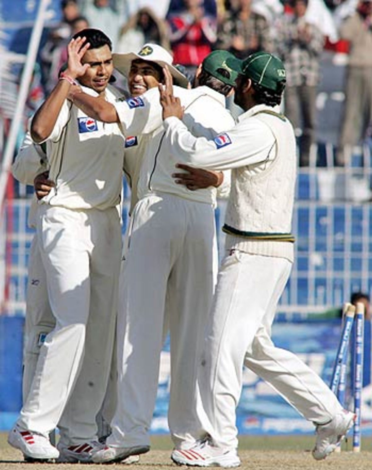 Danish Kaneria celebrates with his team-mates after having Mahendra ...