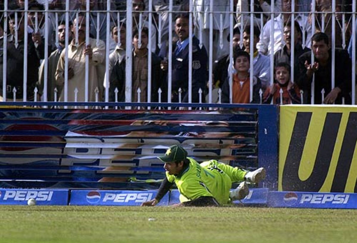 Salman Butt successfully fields the ball at the boundary as the spectators look on ...