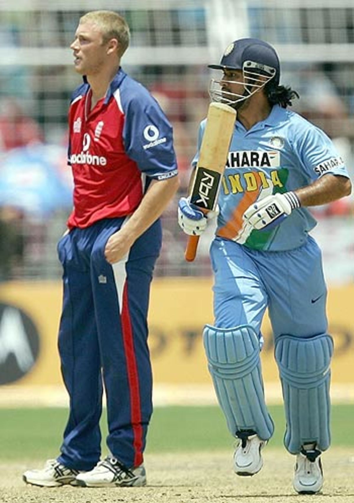 Andrew Flintoff looks on as Mahendra Singh Dhoni pinches a run ...