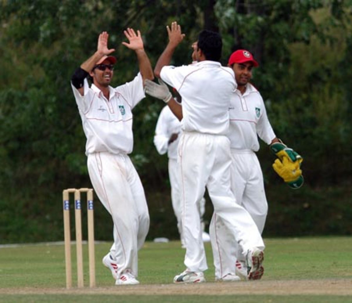 Captain John Davison congratulates his young fast bowler Umar Bhatti ...