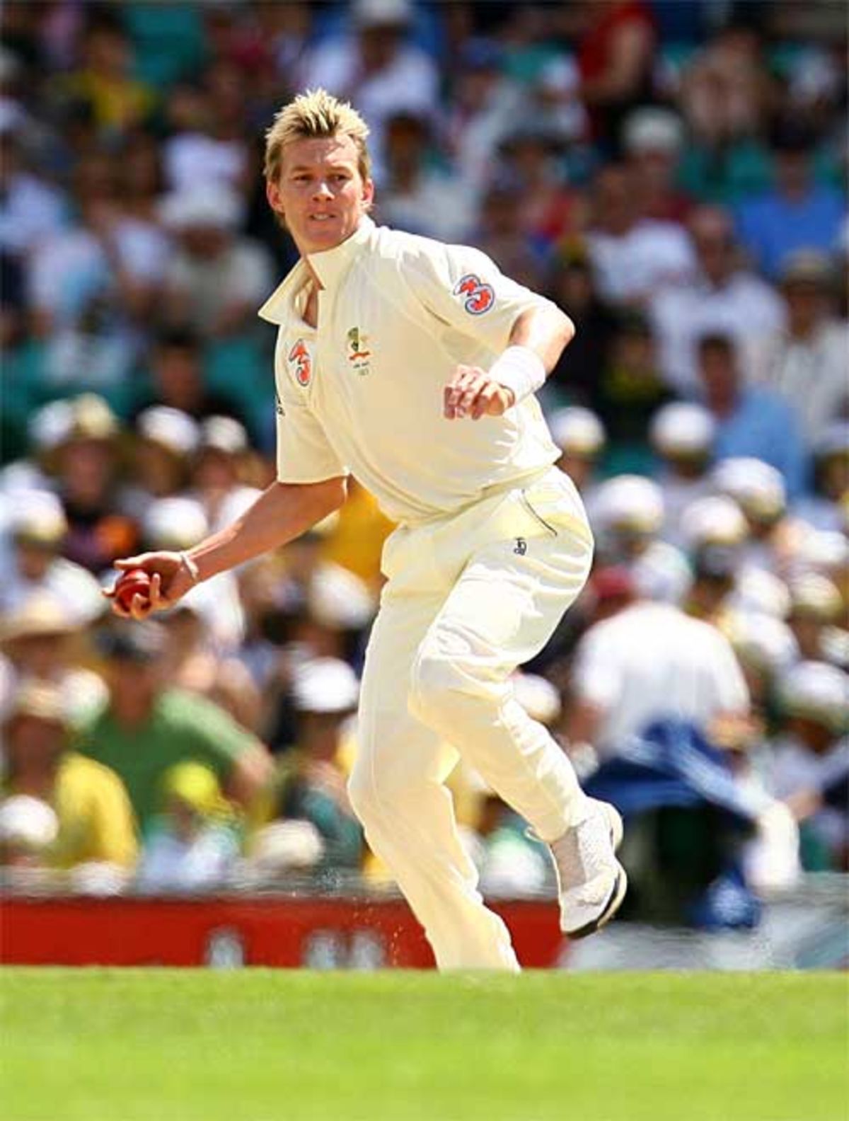 An aggressive Brett Lee shies at the stumps off his own bowling as a ...