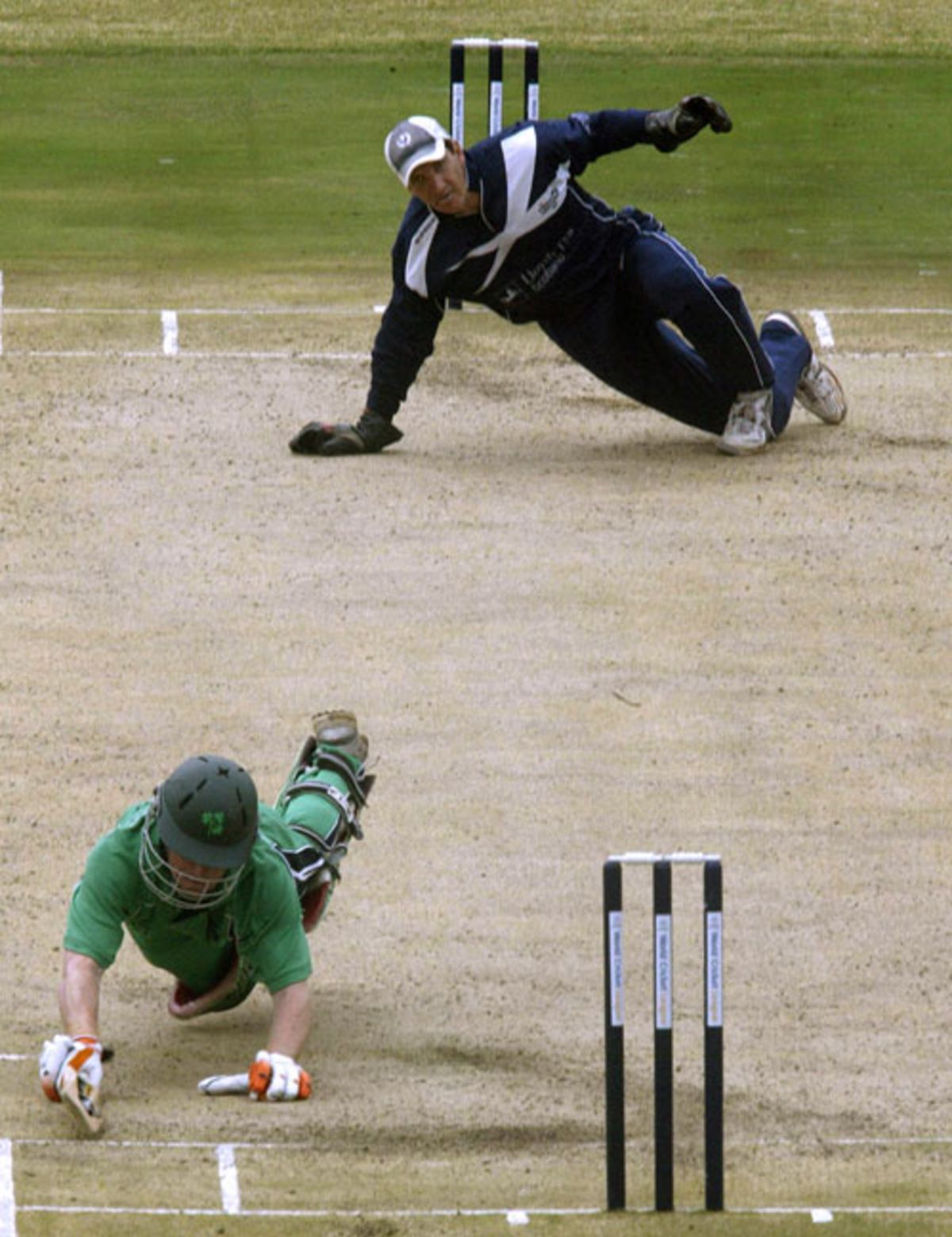 Jeremy Bray dives for safety as Colin Smith shies at the non-striker's ...