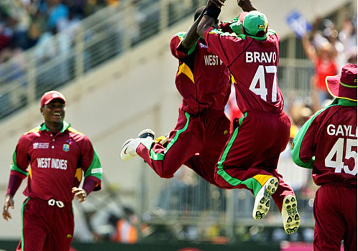 Jerome Taylor and Dwayne Bravo jump up to celebrate a wicket ...