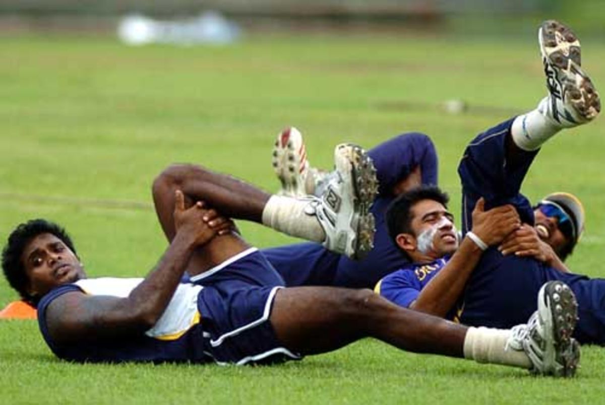 Dilhara Fernando and Ishara Amerasinghe stretch during a practice ...