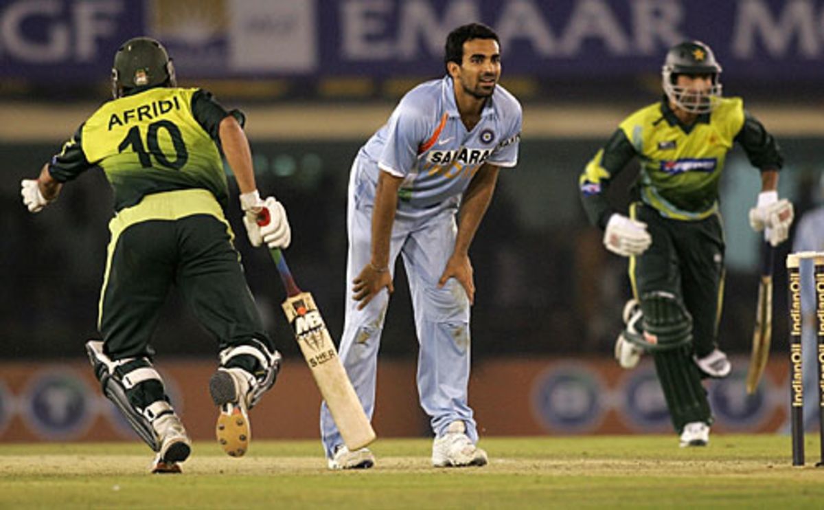 Zaheer Khan waits for the ball to be fielded while the Pakistan batsmen ...