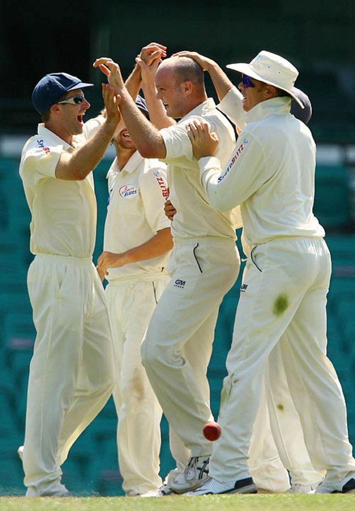 Doug Bollinger's team-mates congratulate him on one of his six wickets ...