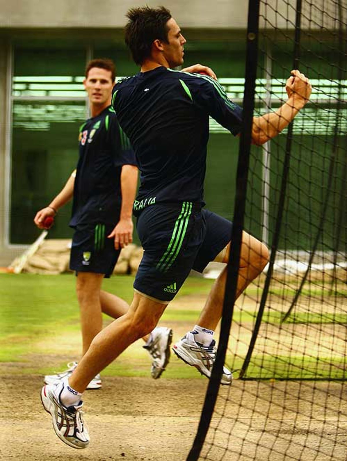 Shaun Tait looks on as Mitchell Johnson bowls in the nets ...