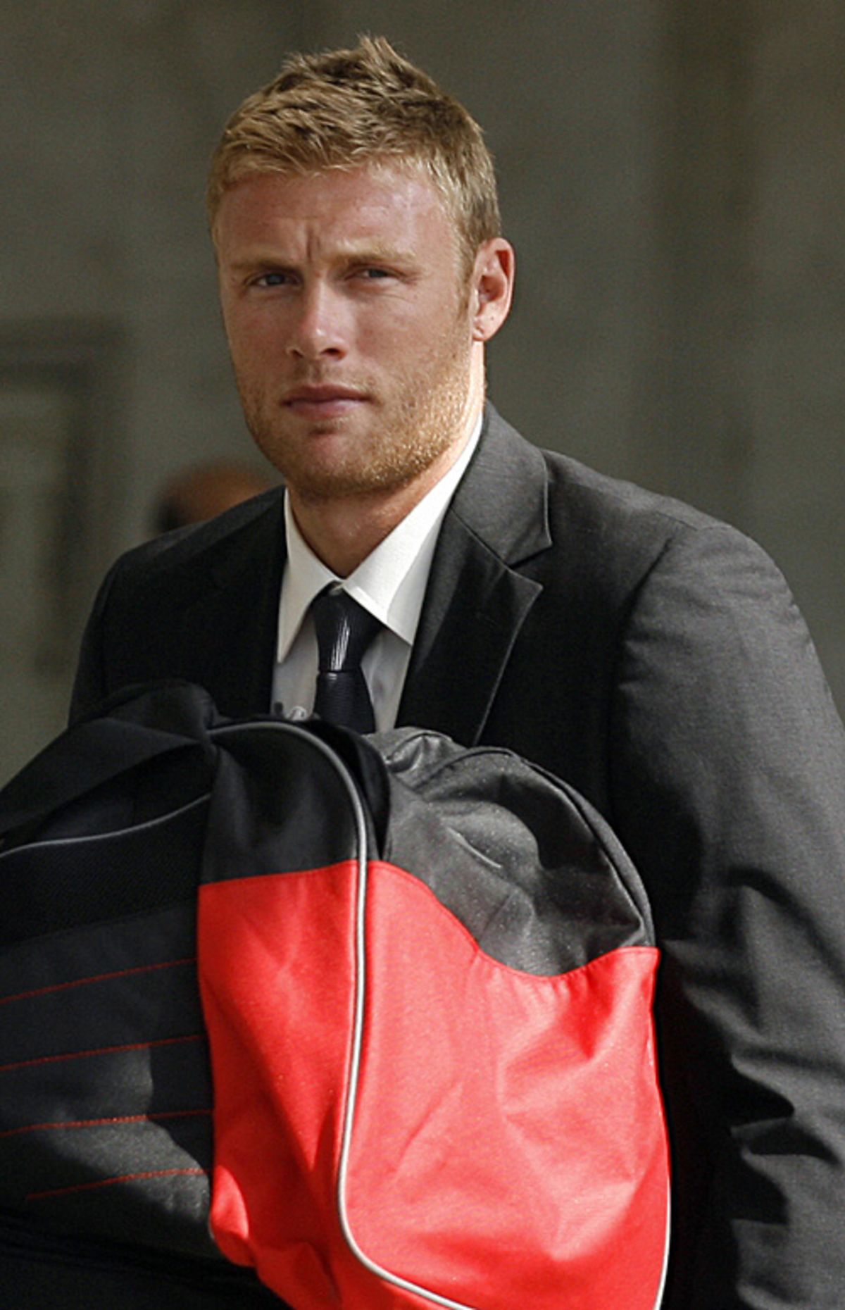 A tired-looking Andrew Flintoff wheels his trolley after arriving in ...