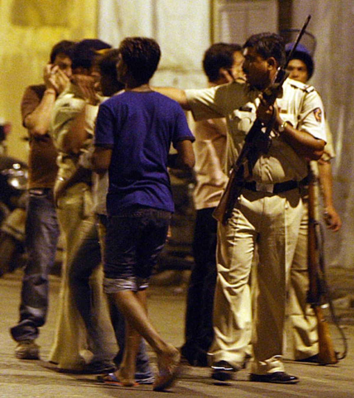 People stand around a damaged vehicle at the site of an explosion in ...