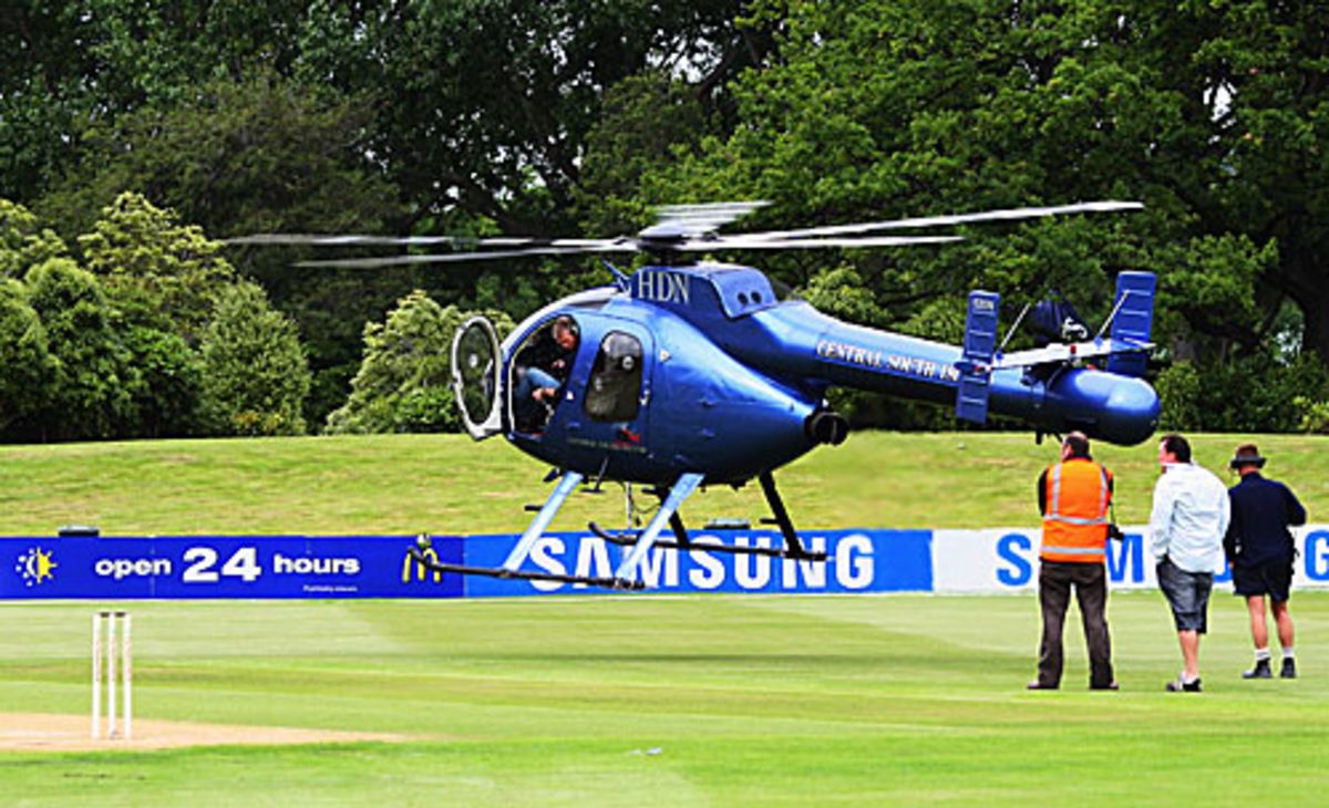 A helicopter makes its way to dry the outfield at the University Oval ...