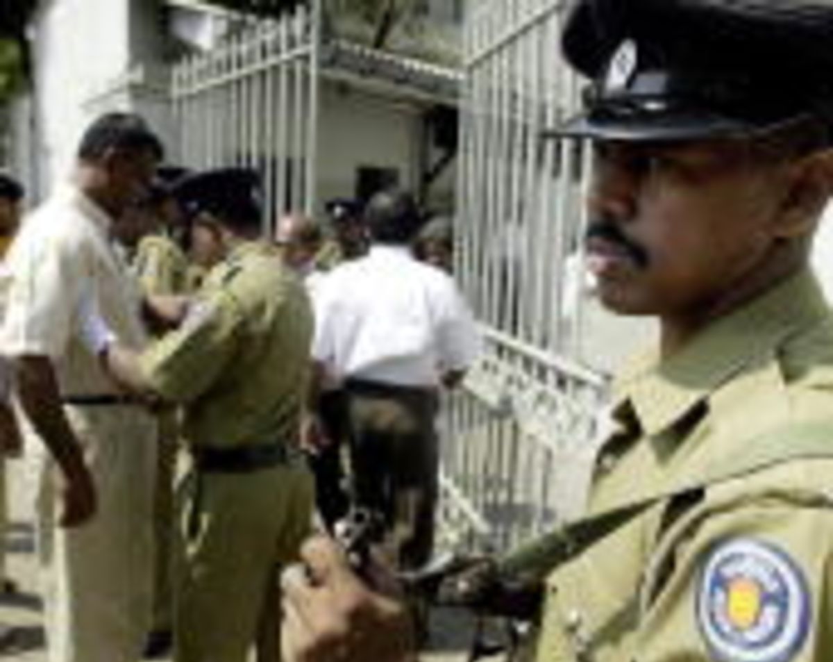 Sri Lankan police officers frisk people entering the magistrate's court ...