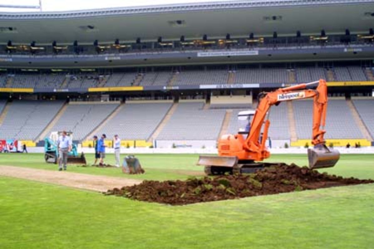 Workers look on as Eden Park's wicket block is dug up immediately after ...