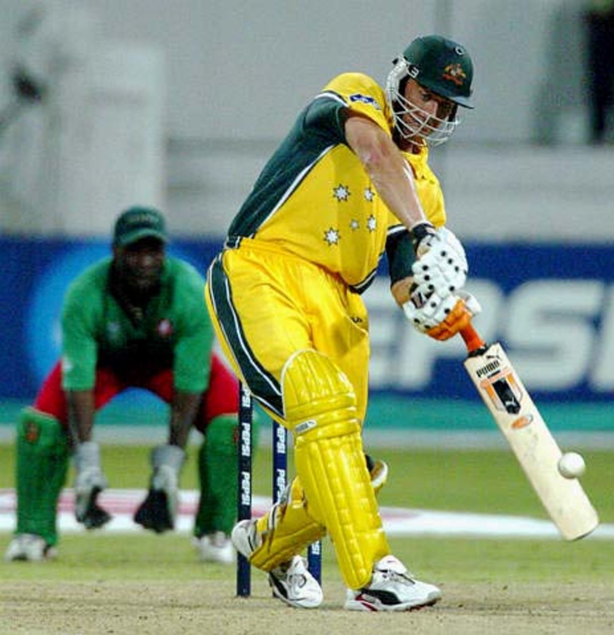 Adam Gilchrist lofts one over the fence as wicket keeper David Obuya ...