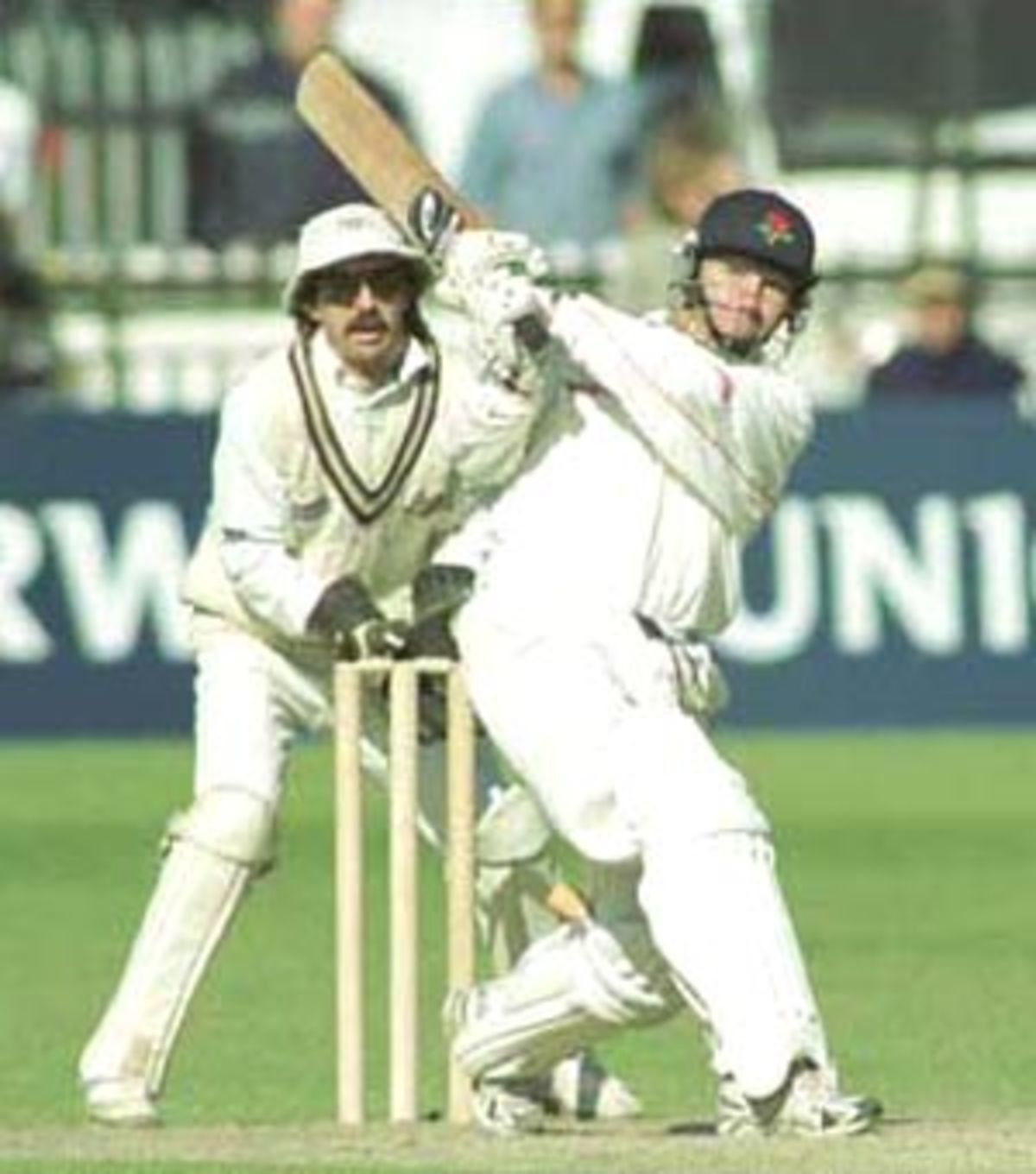 Neil Fairbrother looks on as the ball races past the wicketkeeper ...
