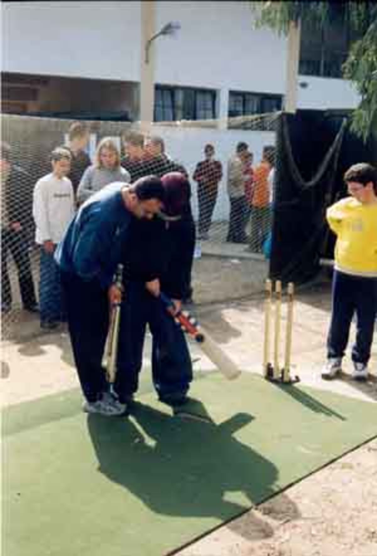 Olympic Day: A PE Teacher is showing at the child how to catch the bat ...