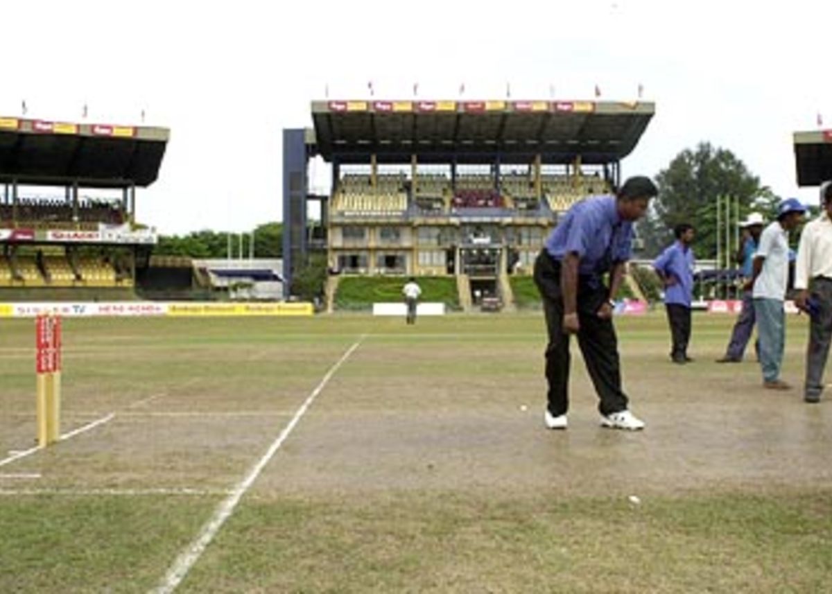 The umpires inspect the damp wicket at the Premadasa Stadium ...