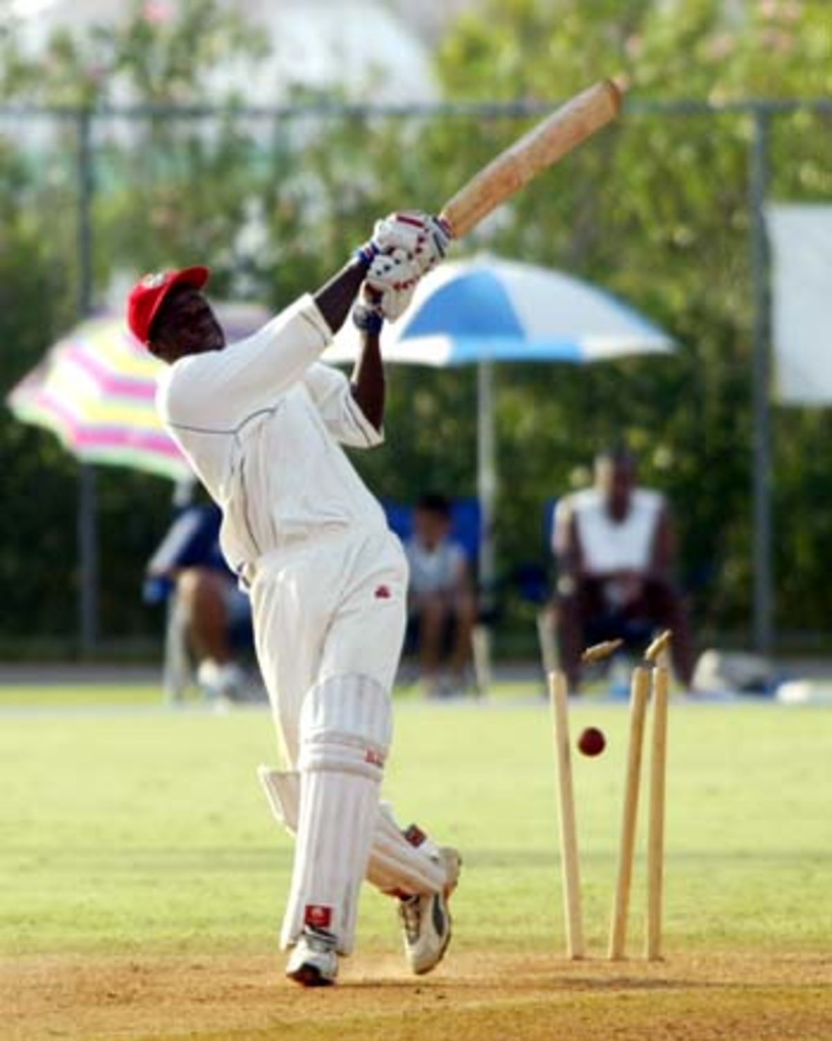 Austin Codrington (Canada) in delivery stride. Umpire is Steve Kalloo ...