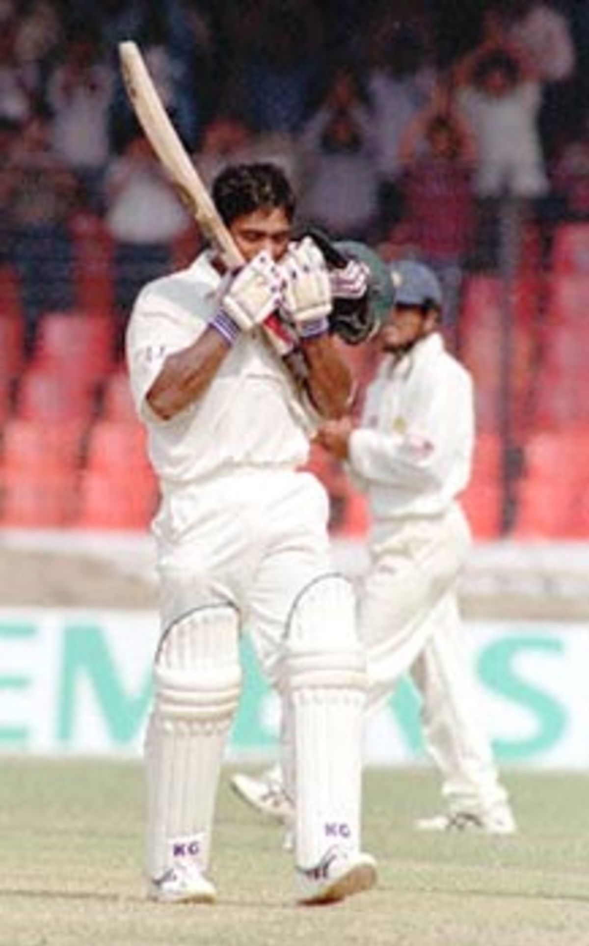 Aminul Islam raises his arms skywards on reaching his century ...