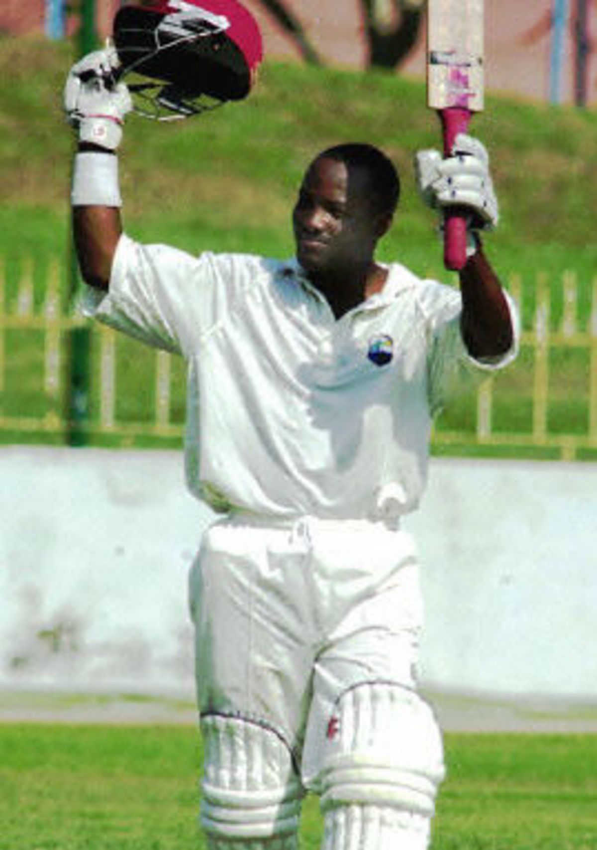 Brian Lara sweeps a ball to the boundary for four as wicketkeeper Sangakkara looks on ...