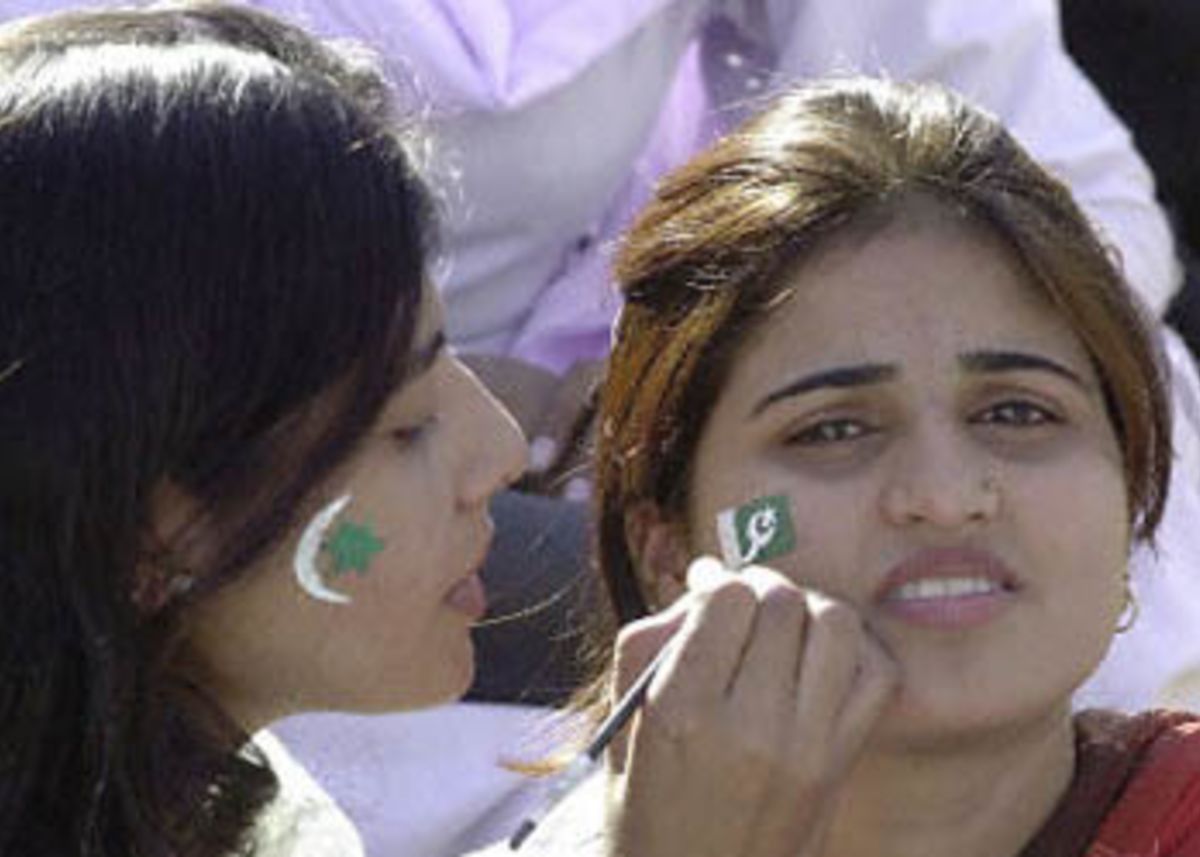 A Pakistani fan gets her face painted with the national colours ...