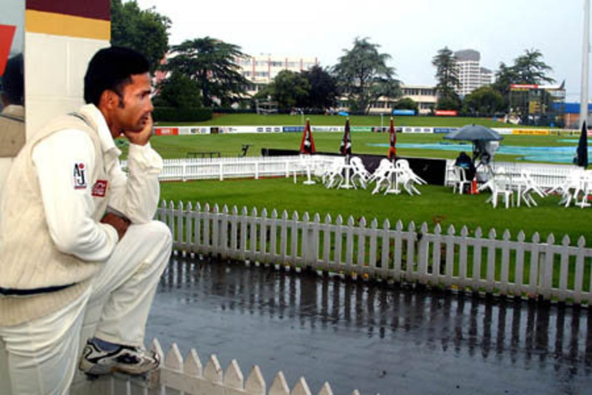 Bangladesh captain Khaled Mashud looks out on to the field as it rains ...
