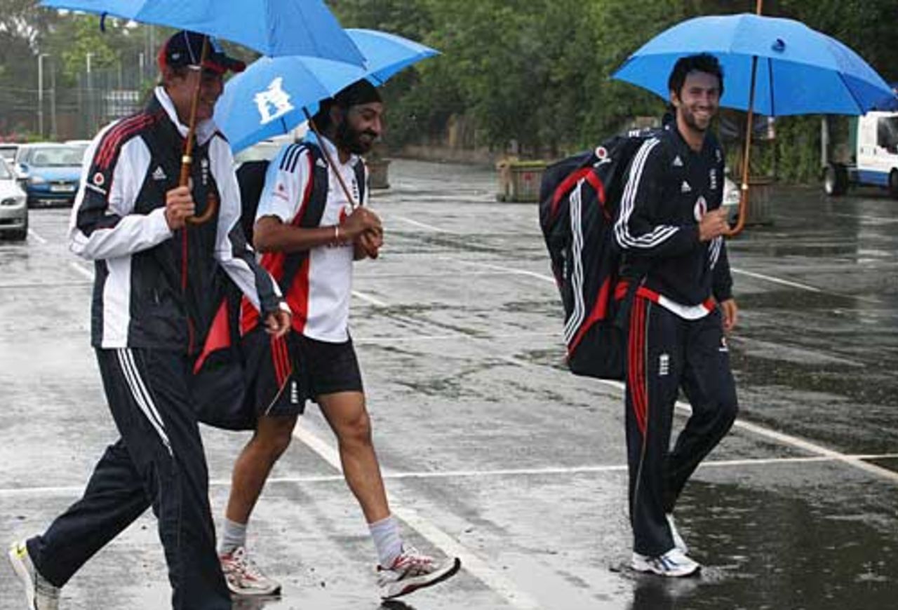 Stuart Broad, Monty Panesar and Graham Onions shelter from the rain ...