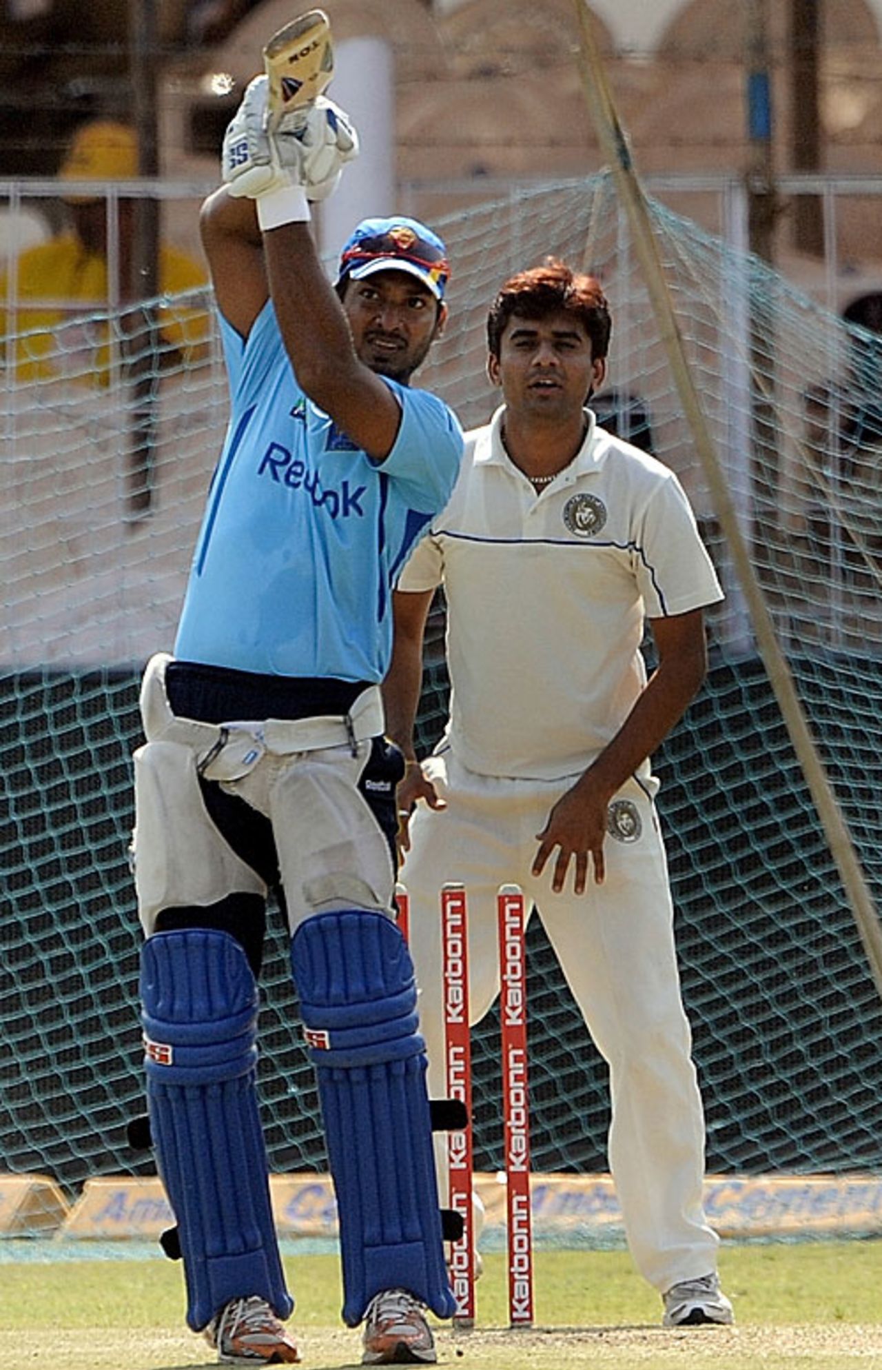 Kumar Sangakkara goes over the top as a young cricketer looks on ...