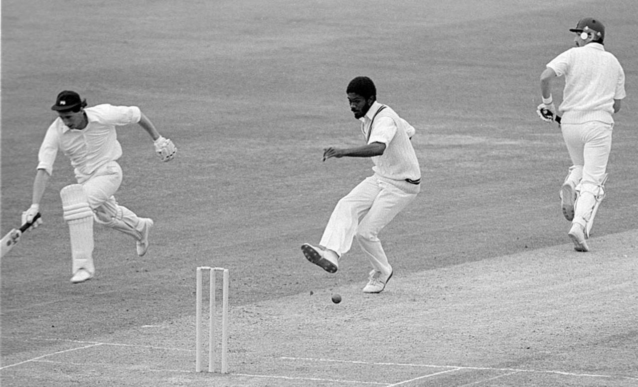 Derek Randall and Graham Gooch take a quick single as Michael Holding ...