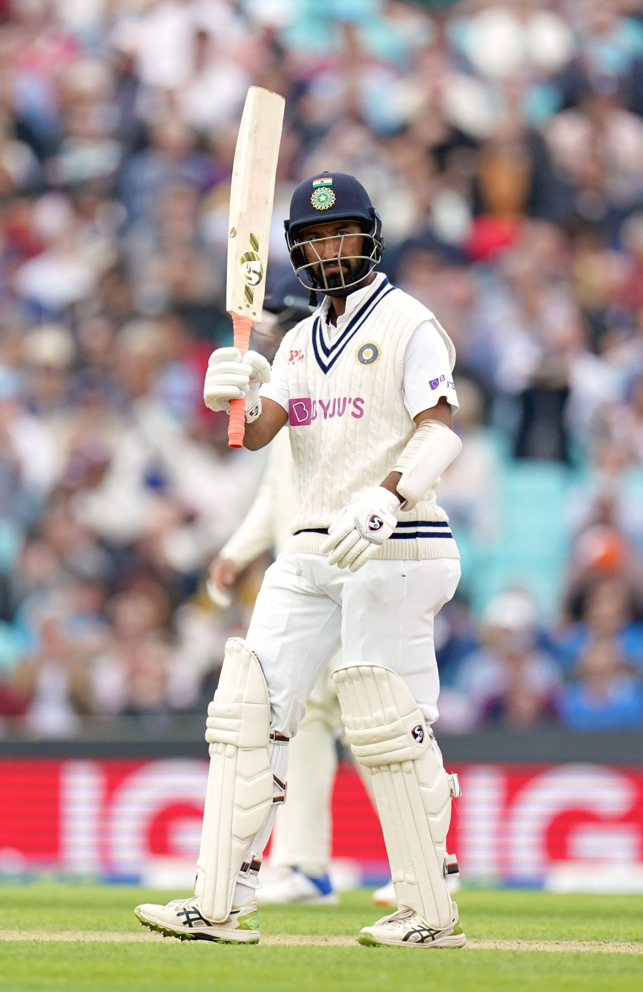 Cheteshwar Pujara raises his bat after registering a fifty ...