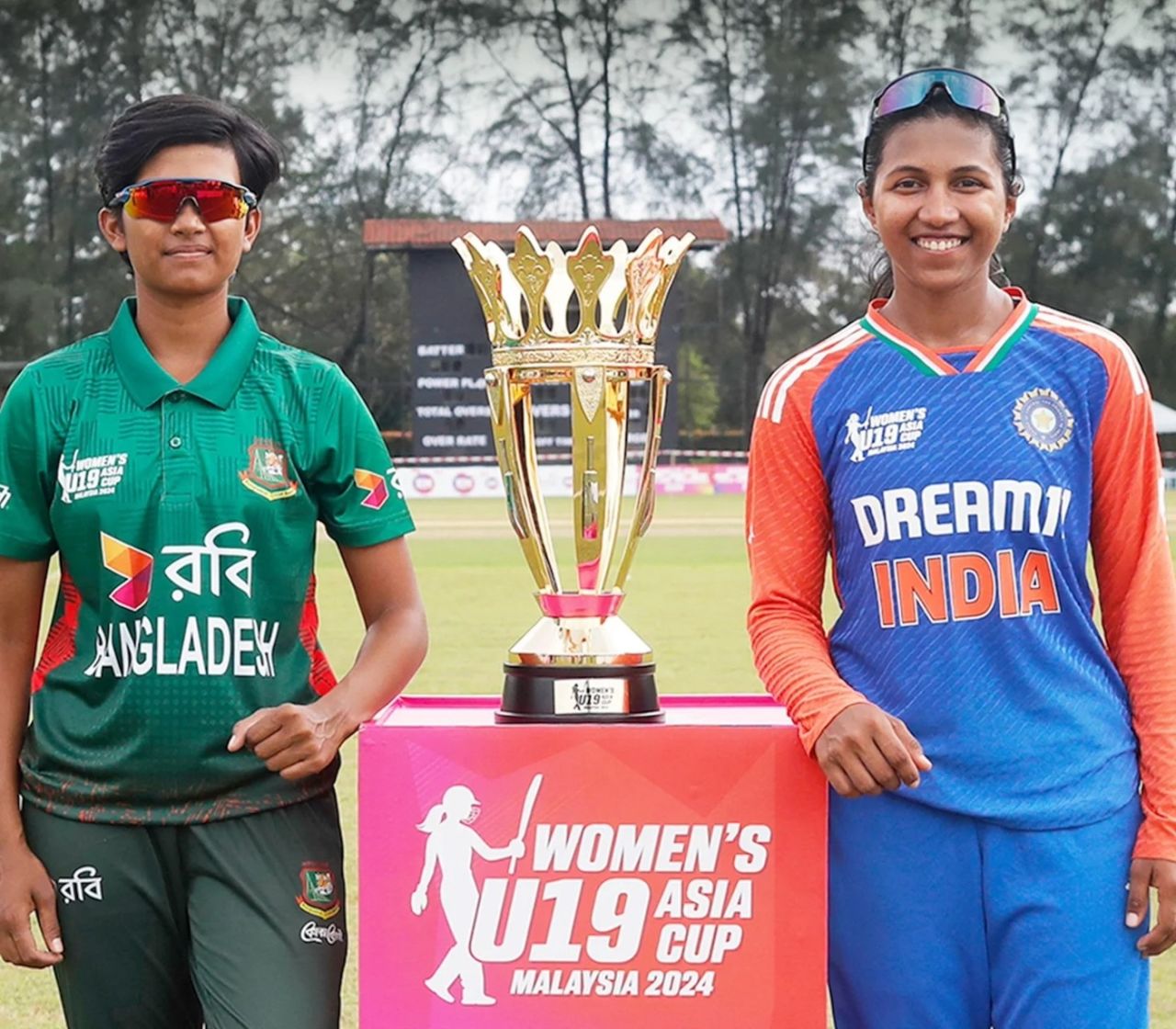 Sumaiya Akter and Niki Prasad, the two captains, pose with the trophy ...