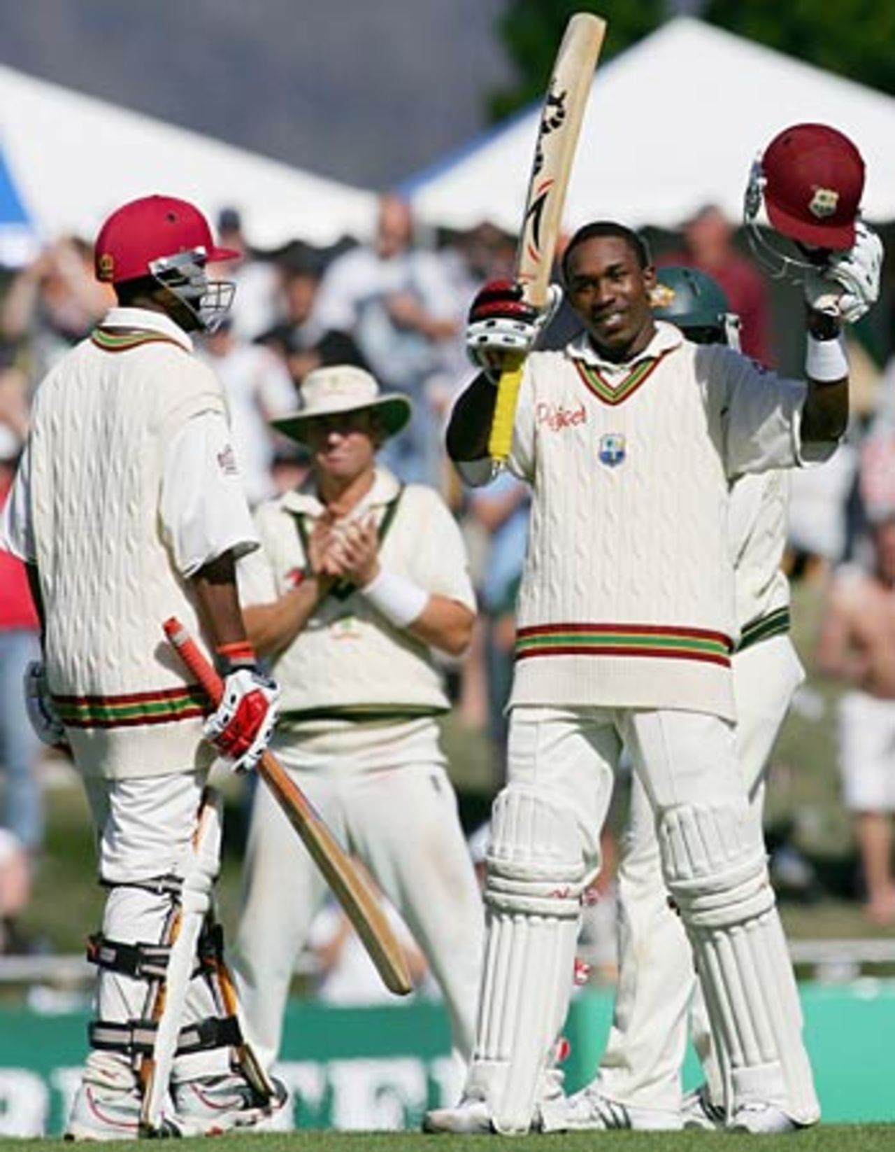 Dwayne Bravo acknowledges the applause after reaching his century as Denesh Ramdin looks on ...