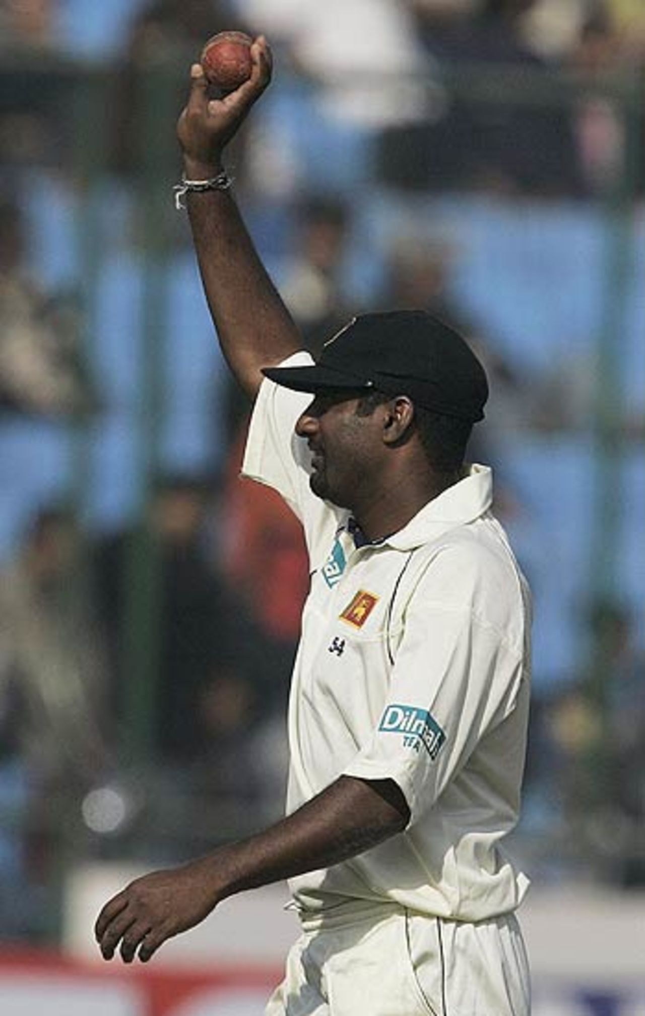 Muttiah Muralitharan raises the ball after his spell of 5 for 23 on the ...
