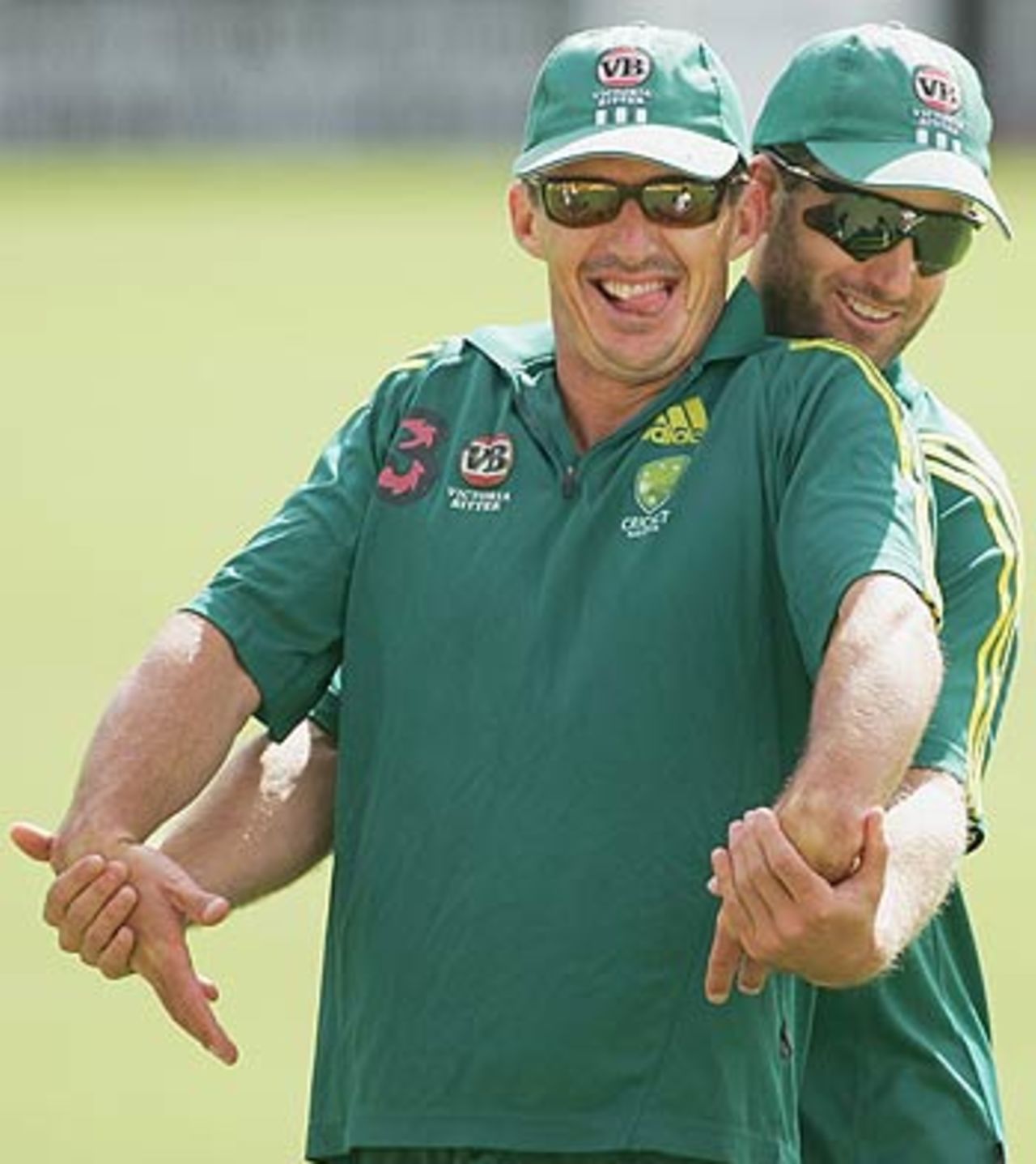Brad Hogg and Simon Katich of Australia do a stretching drill ...