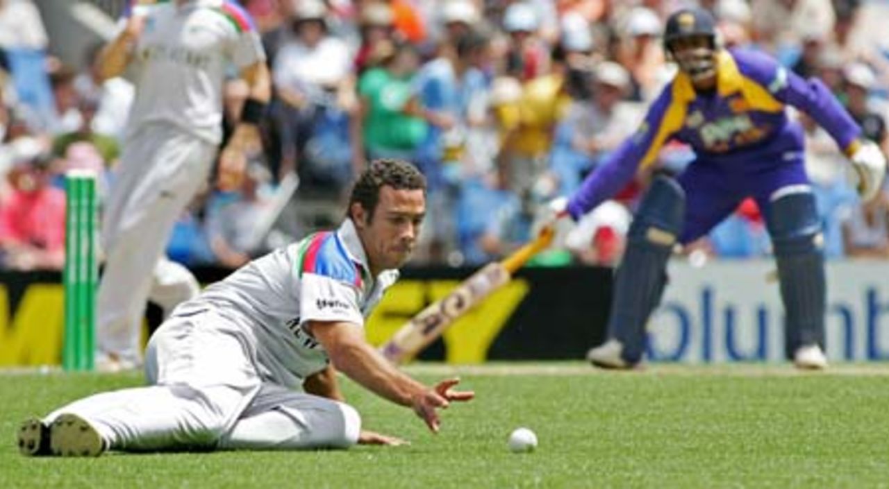 Andre Adams of New Zealand slides to field the ball as Chamara Silva of ...