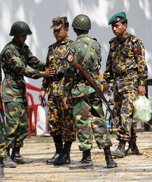 Bangladesh soldiers search another soldier after a mutiny ...